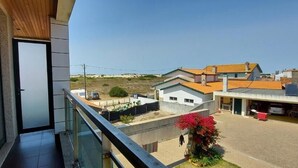 Um bairro residencial com varanda, um edifício com telhado ladrilhado e céu aberto.