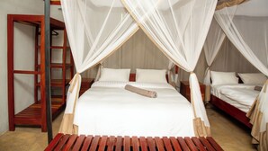 Quarto com cama sob dossel, um banco de madeira e uma escada de madeira.