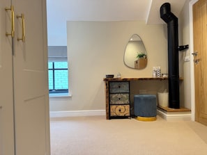 Um quarto com um armário de madeira, um espelho, um cano preto e uma janela.