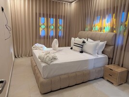 Uma cama bem arrumada com toalhas, uma cabeceira e uma mesa de cabeceira.