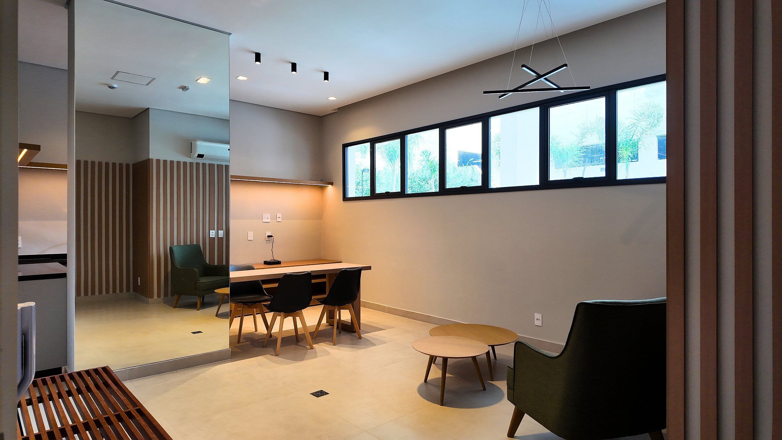 Um interior moderno com área de refeições, espaço de estar e grandes janelas que proporcionam luz natural.