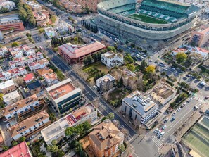 Vista aérea de um horizonte urbano com um estádio grande, edifícios residenciais e uma variedade de espaços comerciais e públicos.