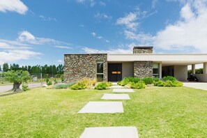 Uma casa moderna com fachada de pedra, garagem e gramado bem cuidado.