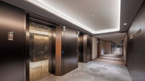 Um elevador moderno com acabamento metálico e porta de vidro texturizado.