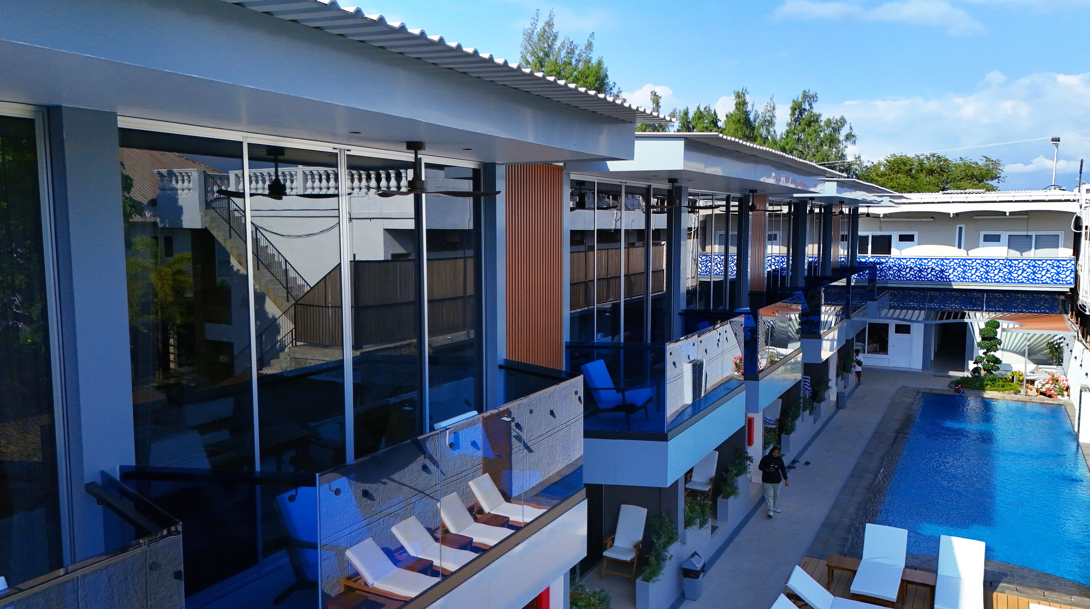 Um hotel moderno com piscina, área de estar externa e vista para a região ao redor.
