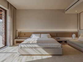 Quarto moderno com cama grande, mesas de cabeceira, um sofá e uma janela ampla.