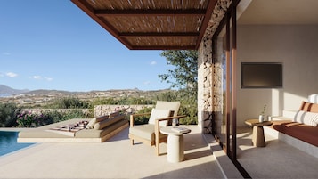 A modern outdoor lounge area with a pool, seating, and a view of the landscape.