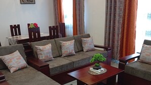 Uma sala de estar moderna com um sofá, uma mesa de centro e uma área de jantar.