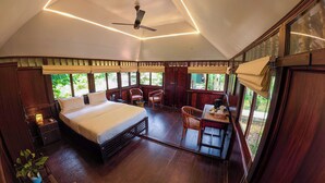 Quarto com cama, mesa de cabeceira, cadeira e escrivaninha com cadeira.