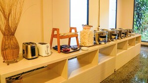 Uma mesa de pequeno-almoço com torradeiras, um vaso e uma cadeira.