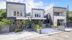 Um edifício residencial moderno com telhado plano, grandes janelas e design minimalista.