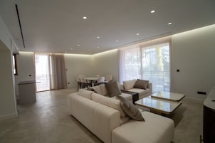 Uma sala de estar moderna com sofá, mesa de centro e área de jantar.
