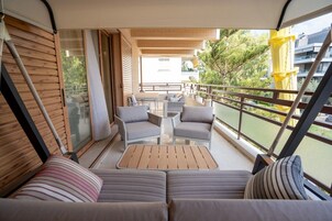 Uma varanda com sofá, cadeiras e mesa.
