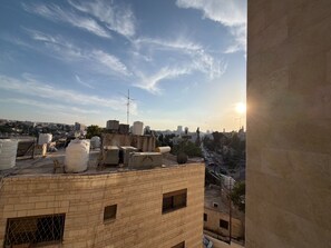 Terraço com reservatórios de água, antena parabólica e vista para a paisagem urbana.
