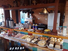Buffet com diversos alimentos, uma máquina de café e um dispensador de água.