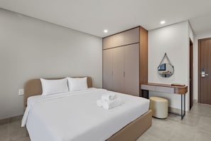 Quarto de hotel moderno com cama, escrivaninha, espelho e guarda-roupa.