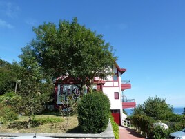 Um edifício com uma placa que diz 'ELKE', rodeado por vegetação e um céu limpo.
