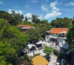 Zona residencial com várias casas, incluindo um edifício de dois andares com varanda e uma construção menor anexa.
