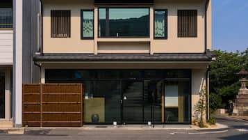 Um edifício de dois andares com fachada moderna, janelas amplas e um portão de madeira tradicional.