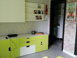 Um quarto com um armário verde e branco, um tabuleiro de xadrez e um cartaz na parede.