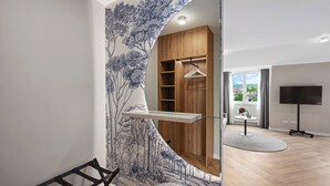 Quarto moderno com armário de madeira, TV e vista para o exterior.