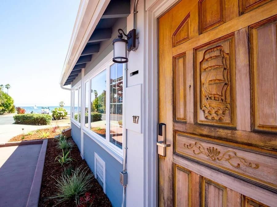Uma casa com porta de madeira, caixa de correio e entrada de automóveis que dá para a rua.