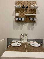 Uma área de refeições com uma parede de arrolhamento exibindo canecas e um espaço para café.