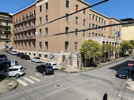 Um edifício de vários andares com área de estacionamento na frente.