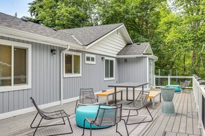 Um terraço com móveis de exterior, uma mesa e cadeiras.