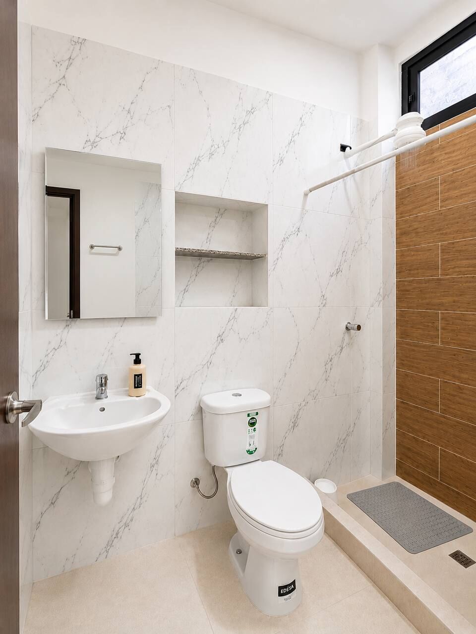 Casa de banho com lavatório, sanita e chuveiro, tudo em branco.