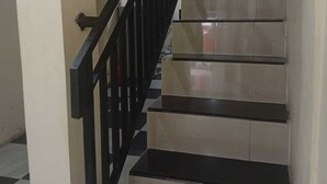 Uma escada com guardaílos pretos e degraus bege.