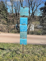 Uma placa de sinalização indicando várias opções de rota e distâncias em quilômetros.