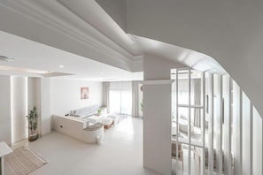 Uma sala de estar espaçosa com sofá, mesa de centro e uma planta.