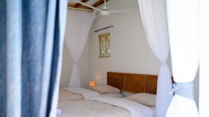 Quarto com cabeceira de madeira, abajur e janela com vista.