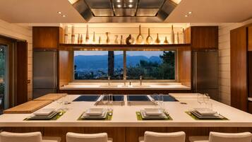 Cozinha moderna com uma ilha grande, eletrodomésticos de aço inoxidável e vista para as montanhas.