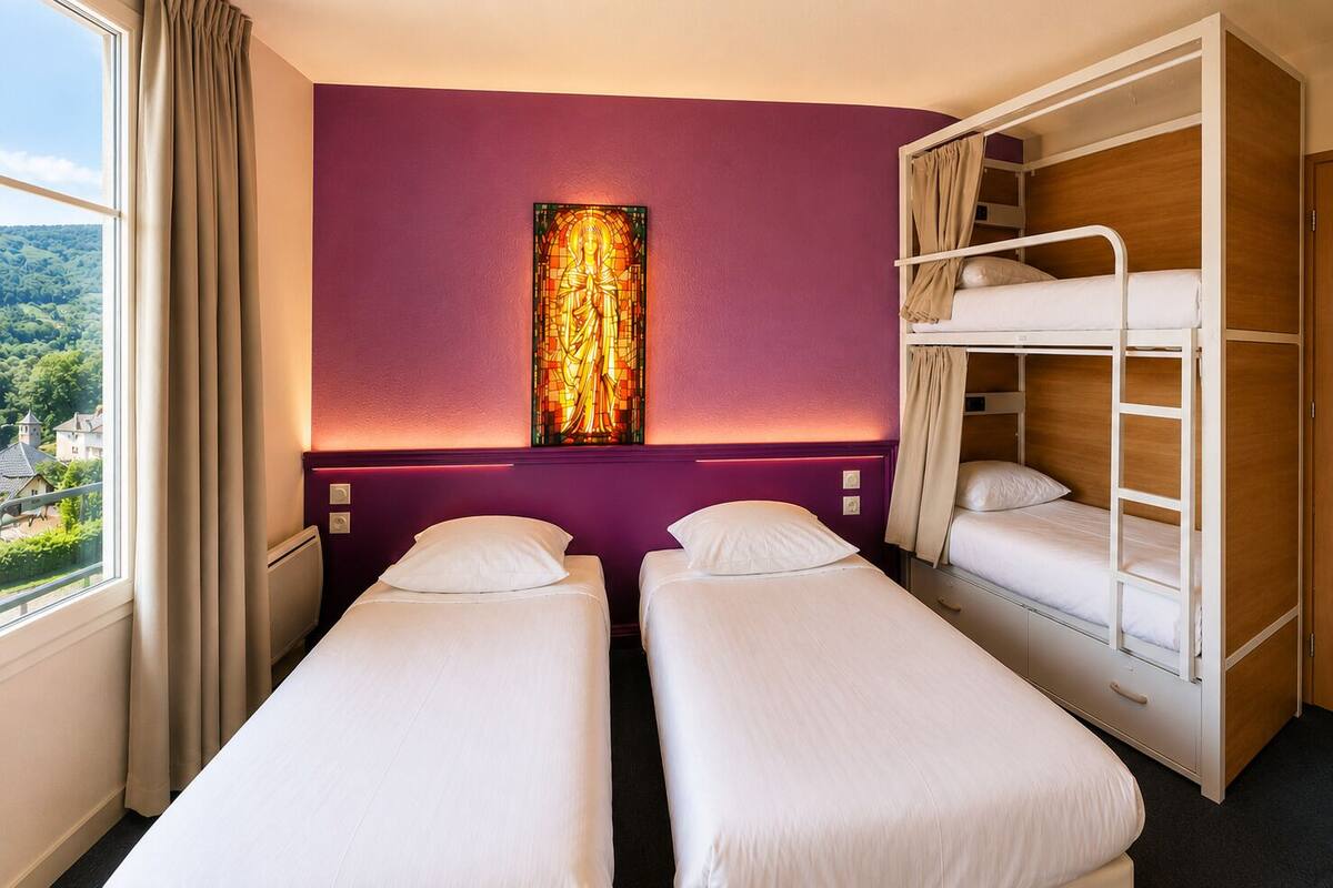 Quarto de hotel com duas camas de solteiro, uma cama beliche, uma janela grande com cortinas e uma obra de arte em vitral na parede.