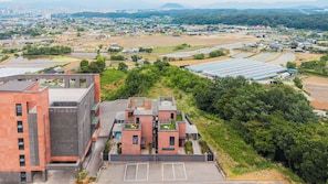 Um edifício moderno com estacionamento e áreas verdes.