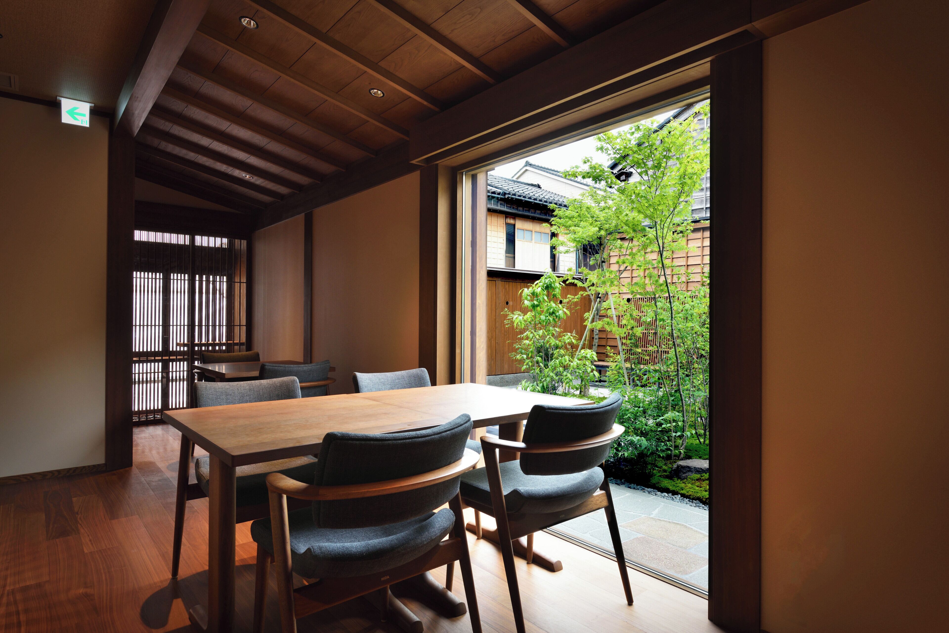 Um quarto em estilo tradicional japonês, com tatames, uma mesa de madeira e cadeiras.