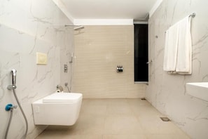 Uma casa de banho moderna com sanita, lavatório e chuveiro.