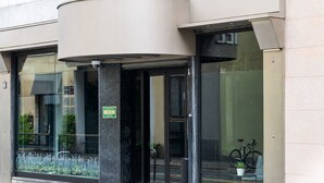 Entrada de hotel com porta giratória, acesso de vidro e indicação de classificação 4 estrelas.