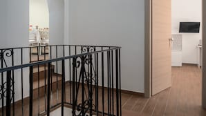 Um interior moderno com escada, televisão de tela plana e área de cozinha.