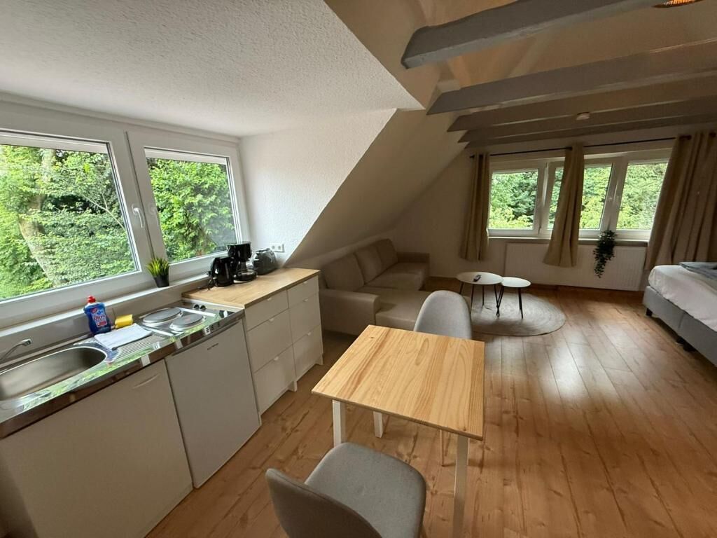 Uma cozinha compacta com área de refeições, um sofá e uma pequena mesa.