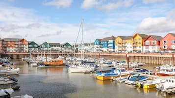 Marina com edifícios coloridos e diversos barcos atracados.