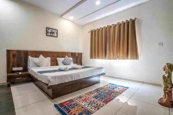 Quarto com cama, mesa de cabeceira e tapete decorativo.