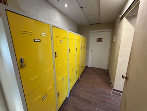 Corredor com armários amarelos e uma porta marcada com um sinal 'A'.