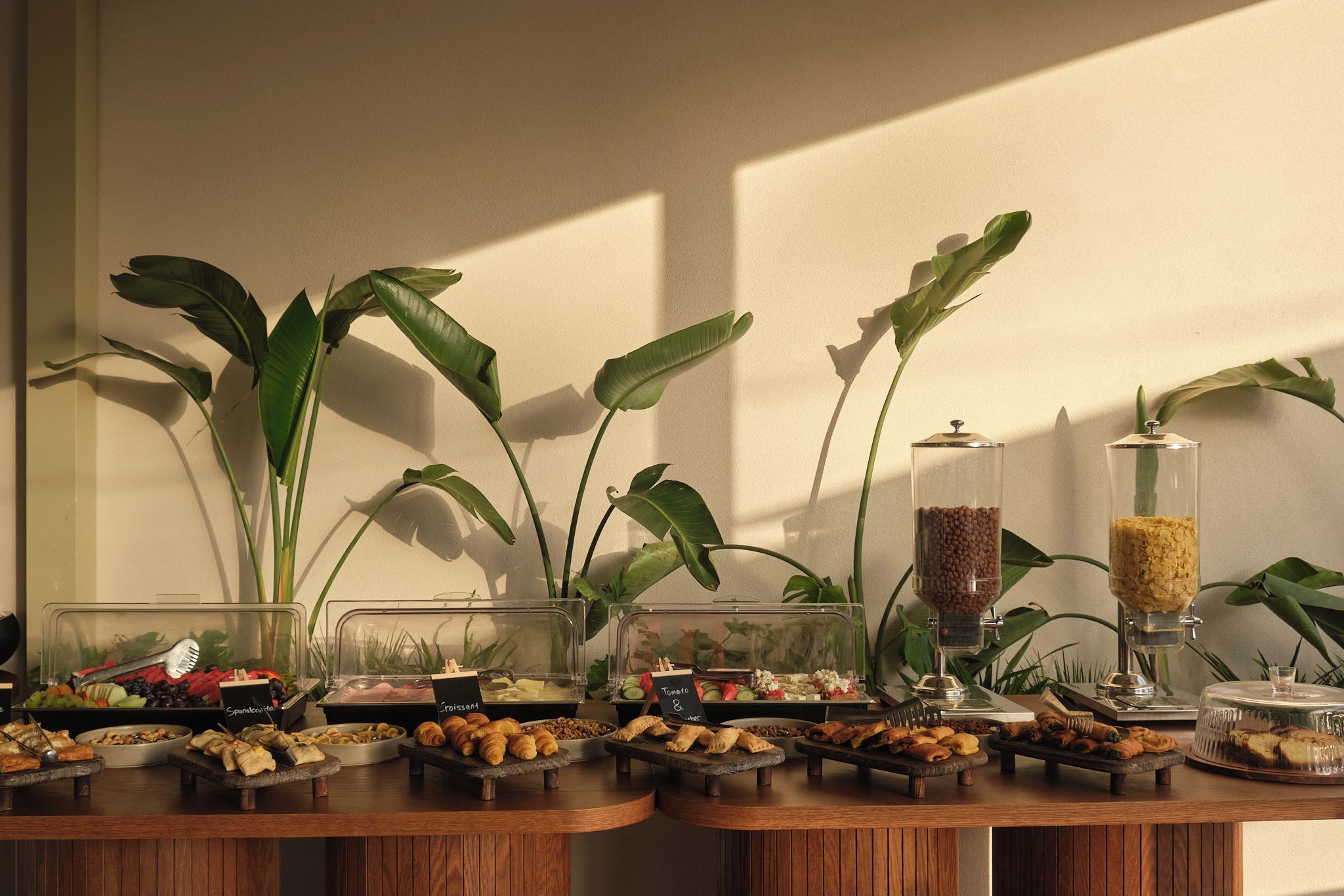 Disposição de buffet com diversos alimentos e um dispensador de café.