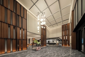 Um hall amplo com balcão de recepção, área de estar e design de teto moderno.