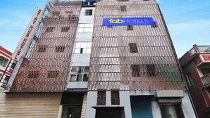 Um edifício com vários andares, com a placa 'fab HOTELS' e parte da placa 'TOYAHUB HOTEL'.