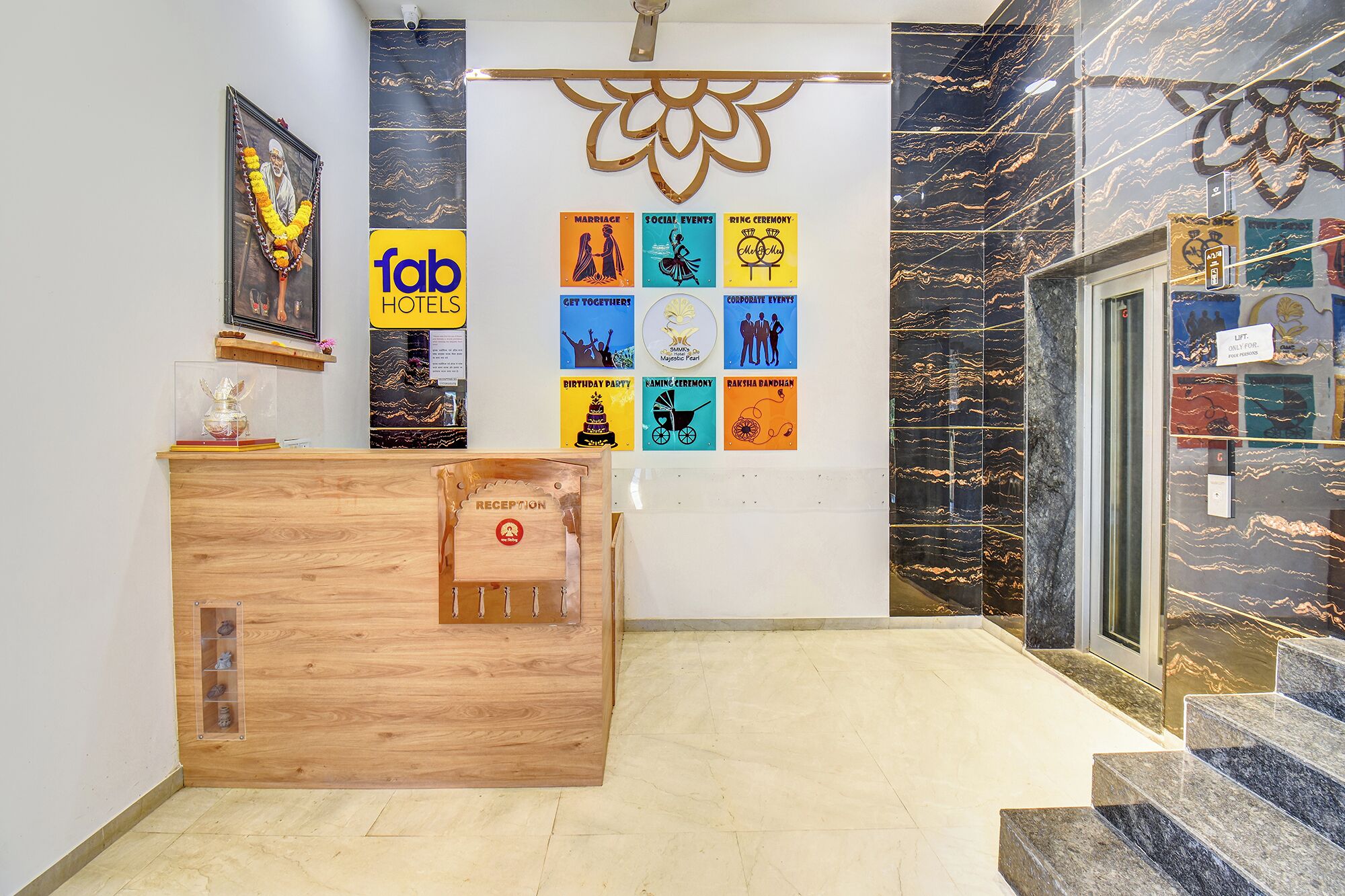Uma área de recepção de hotel com uma mesa de madeira, placa de recepção e um painel com cartazes de eventos.