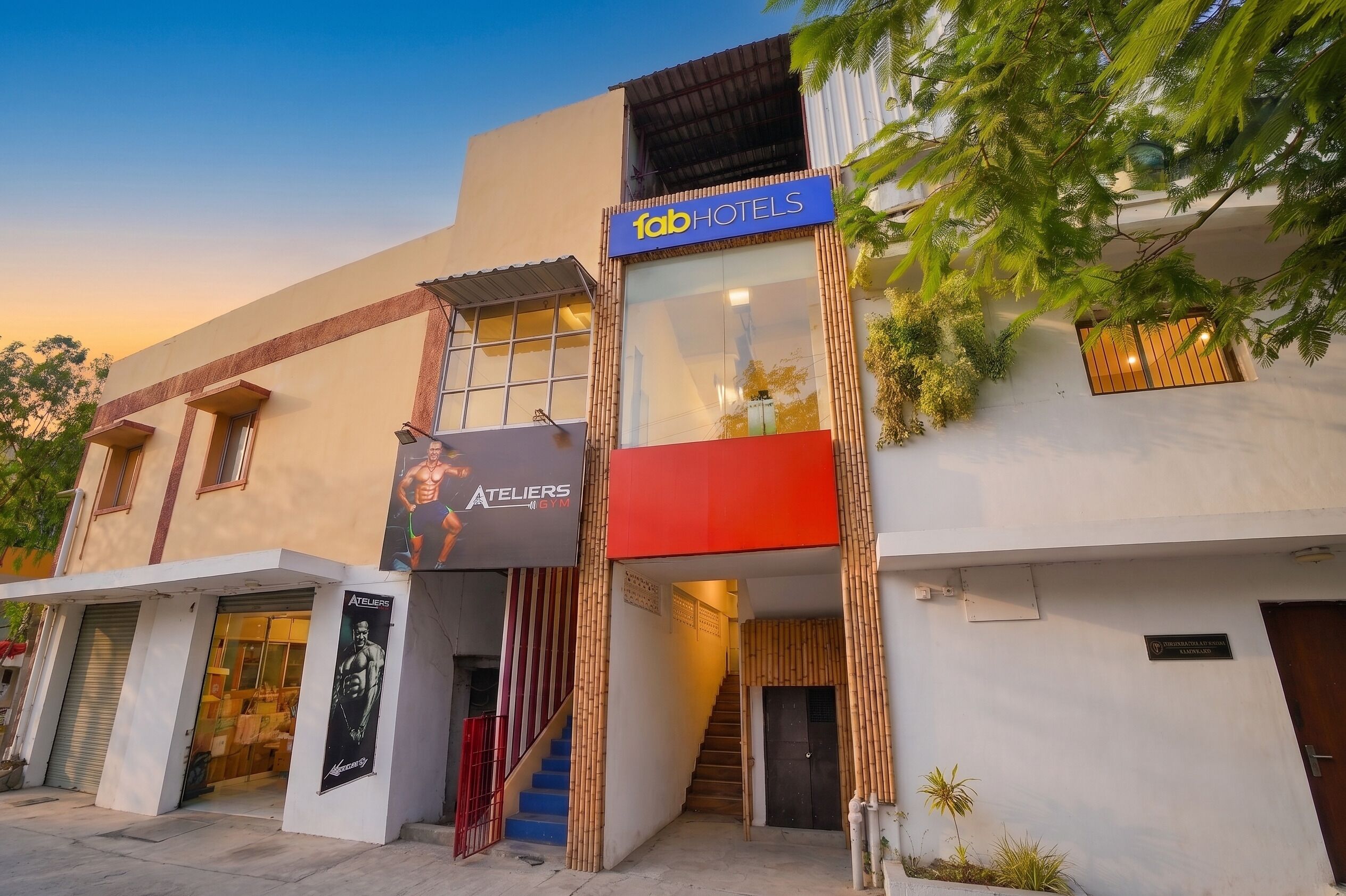 Hotel com academia no andar térreo, escada e placa indicando 'Ateliers Gym'.